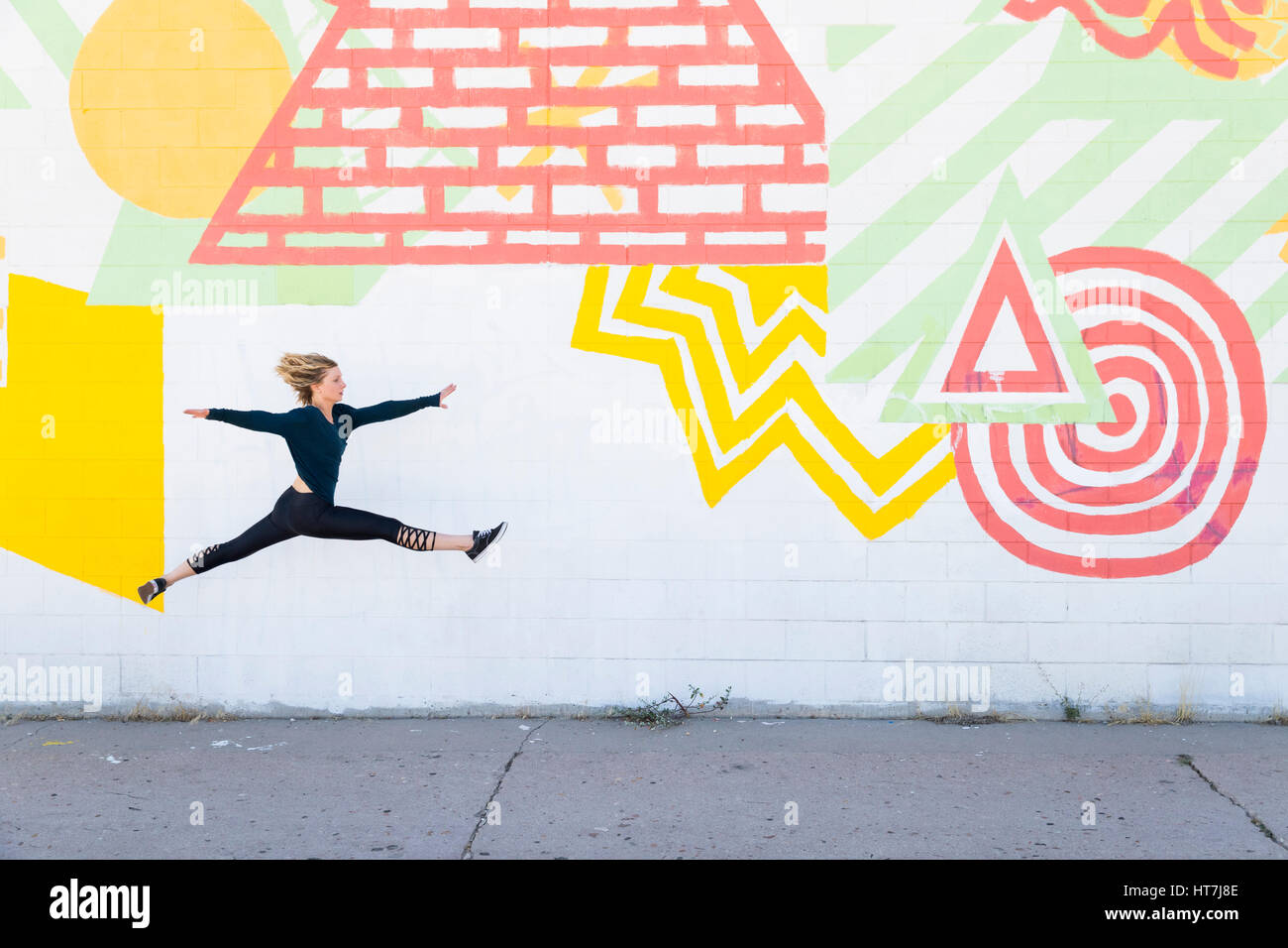 Young Woman Doing A Split Up In Front Of Street Art In Denver, Colorado ...