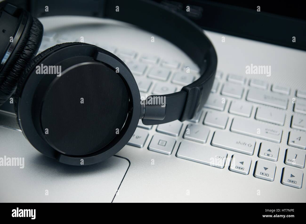 Wireless headphones on laptop keyboard. Music and gaming concept Stock ...