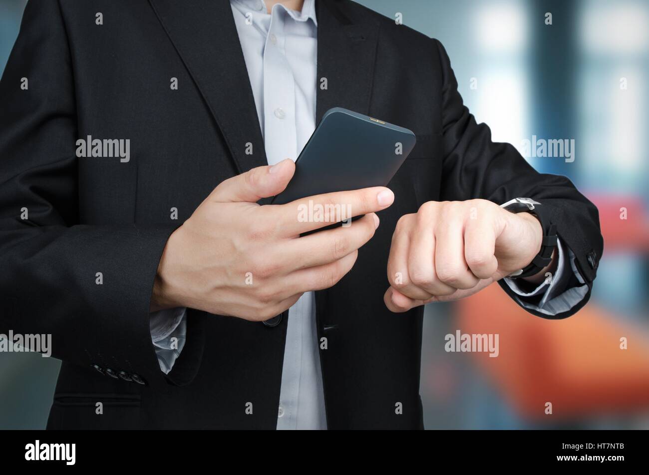 Businessman with smartphone and smartwatch working in office Stock ...