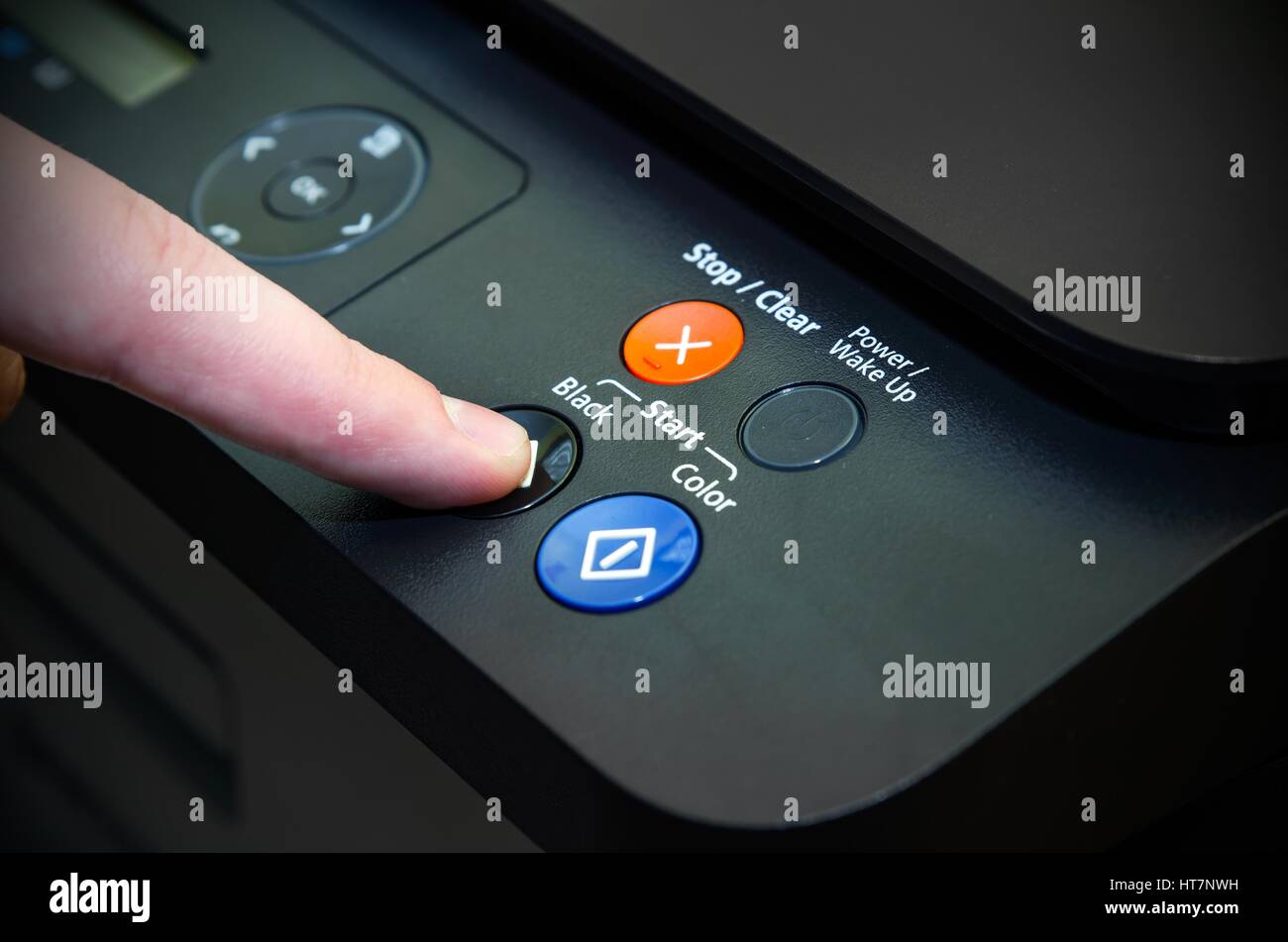 Man holding finger on start button of laser printer Stock Photo - Alamy