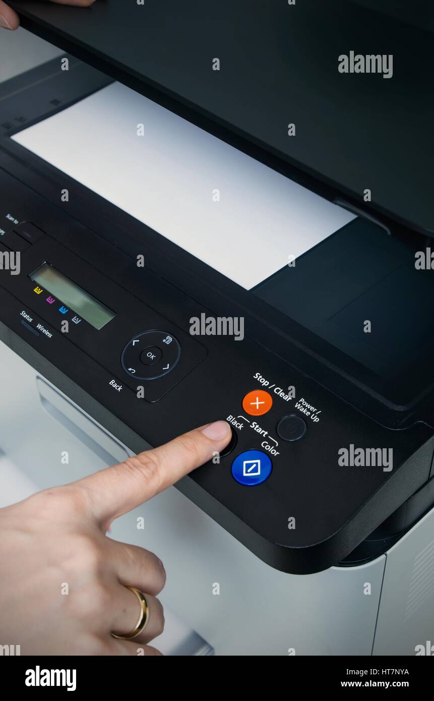 Woman switching on start button of laser printer device Stock Photo - Alamy