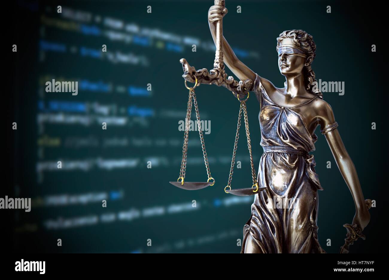 Justice statue with code on screen in background. Internet crime ...