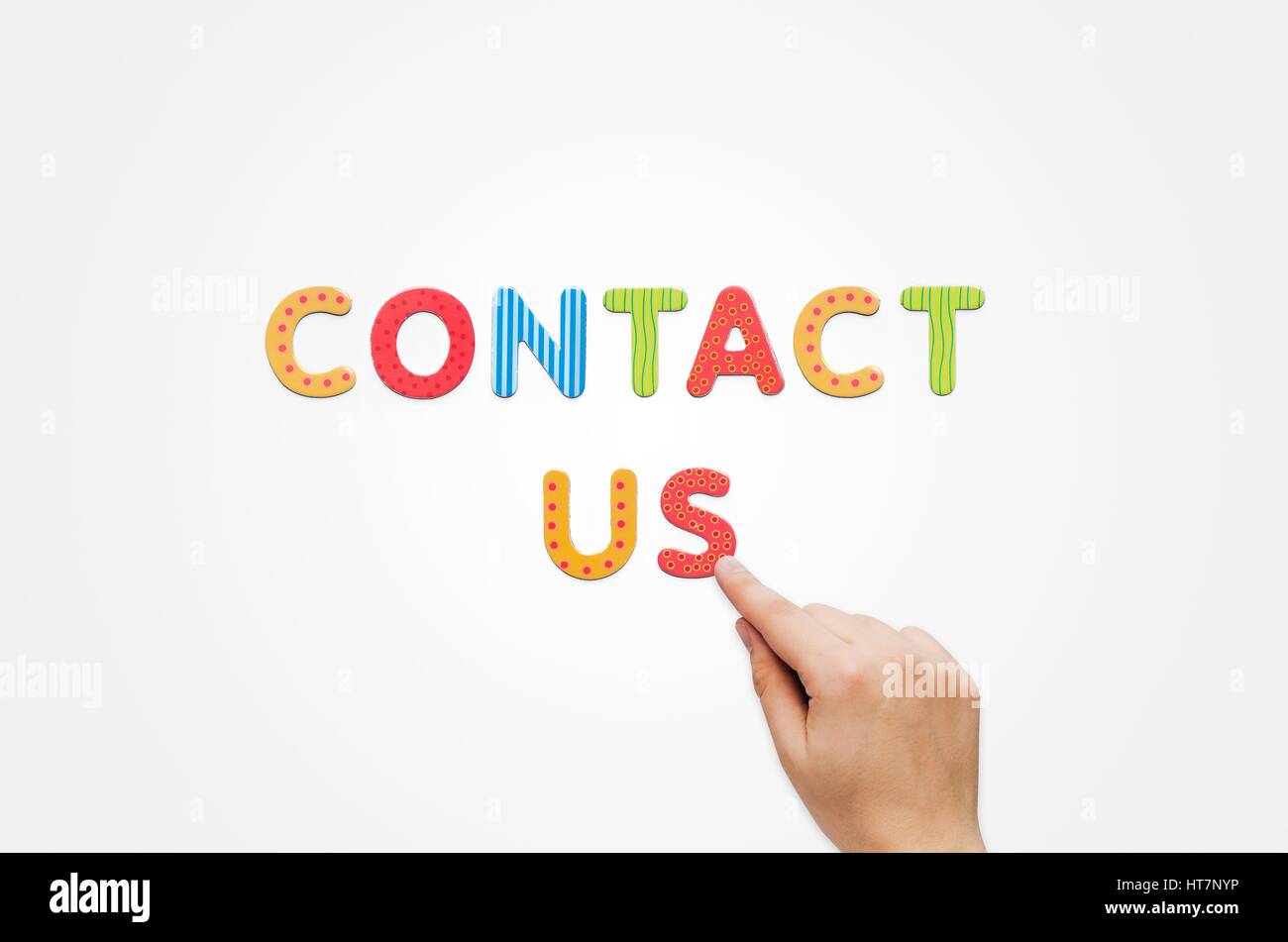 Hand put the words Contact Us with magnetic letters. Colorful alphabet ...