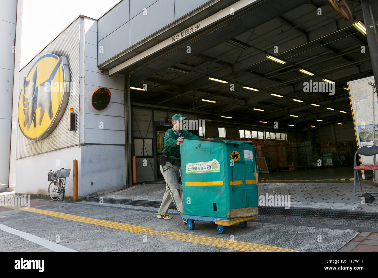 Tokyo, JapanA Yamato Transport worker pushes a trolley while past the ...