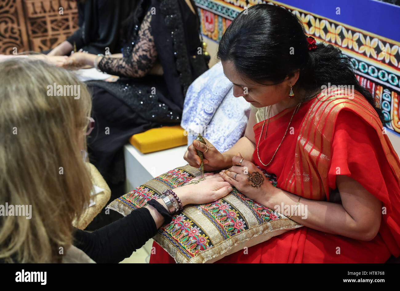 Berlin, Germany. 8th Mar, 2017. A staff member of India booth paints ...
