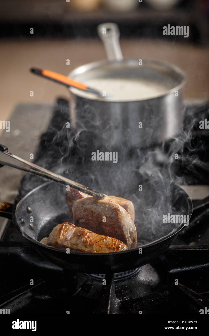 Piece of pork meat frying in the pan Stock Photo - Alamy