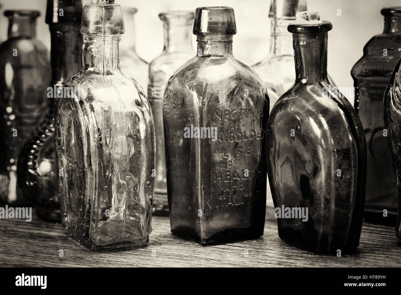 Selection of coloured glass bottles on a rustic background Stock Photo ...