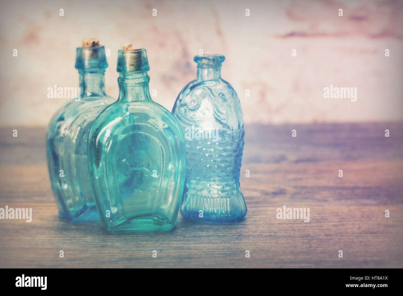Selection of coloured glass bottles on a rustic background Stock Photo ...