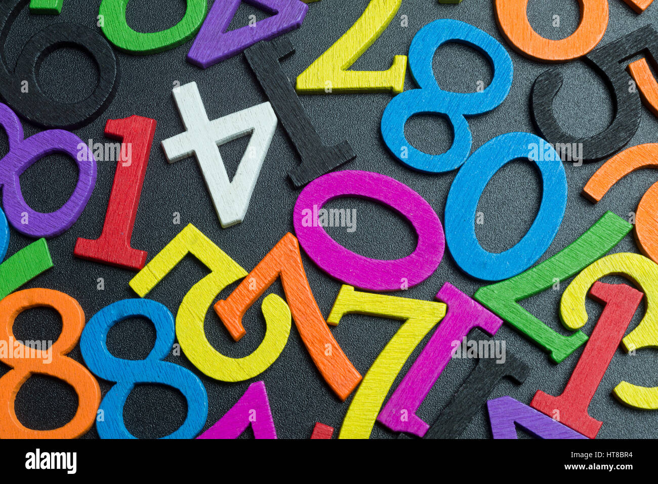 The numbers of different colors lying on a black floor Stock Photo - Alamy