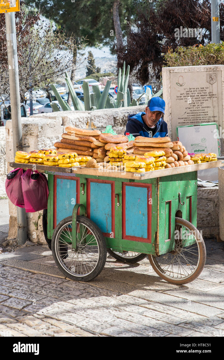 A street vendor pushs his bread cart through the streets of Jerusalem ...