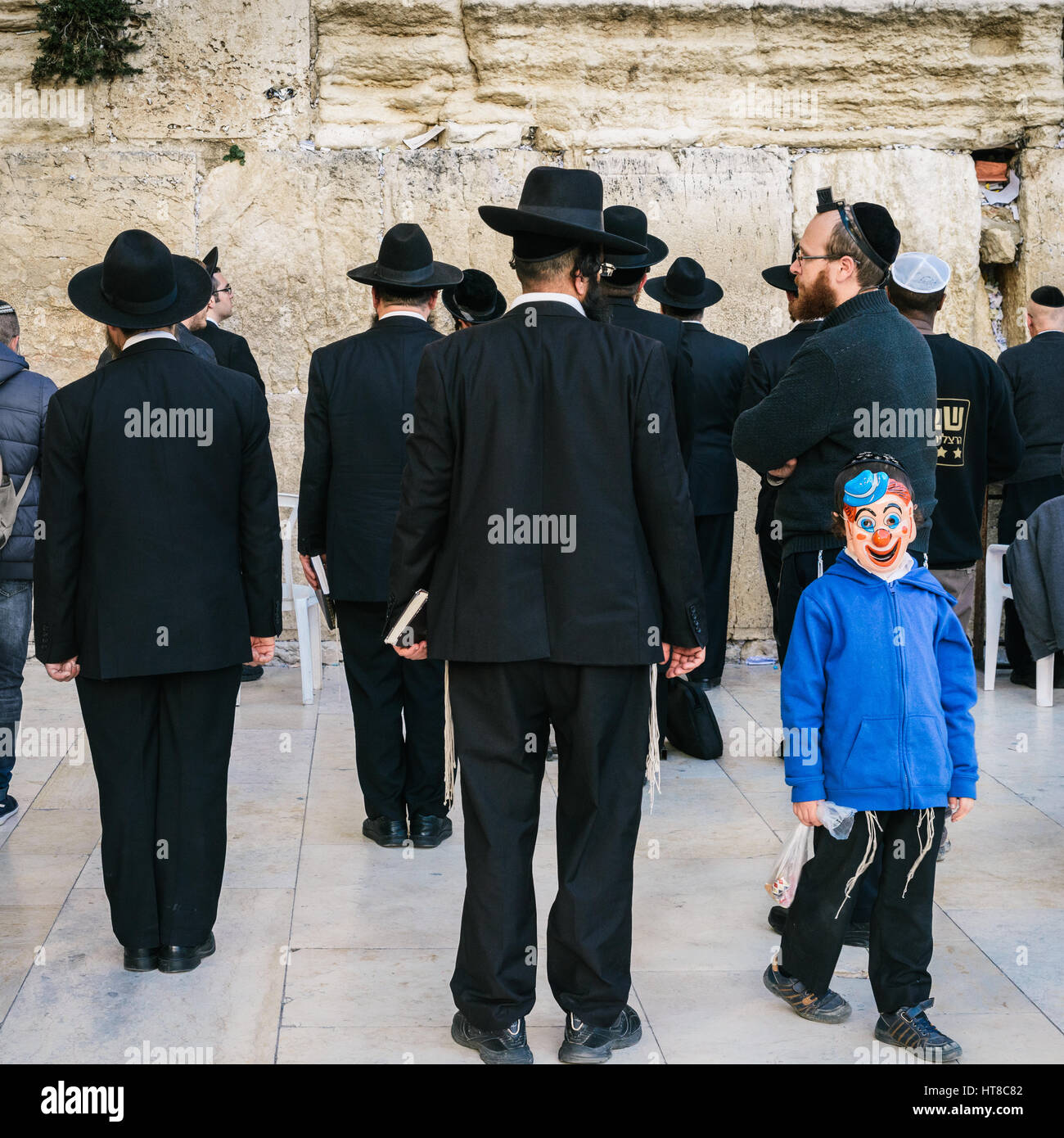 A little boy dressed in a mask next to the Western Wall in Jerusalem ...