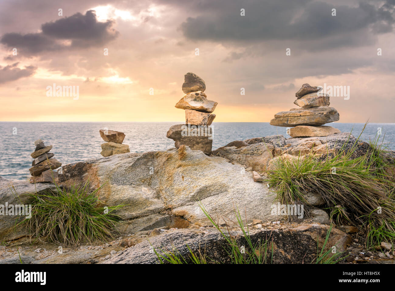 Stacked stones on a beach in Thailand at sunset Stock Photo - Alamy