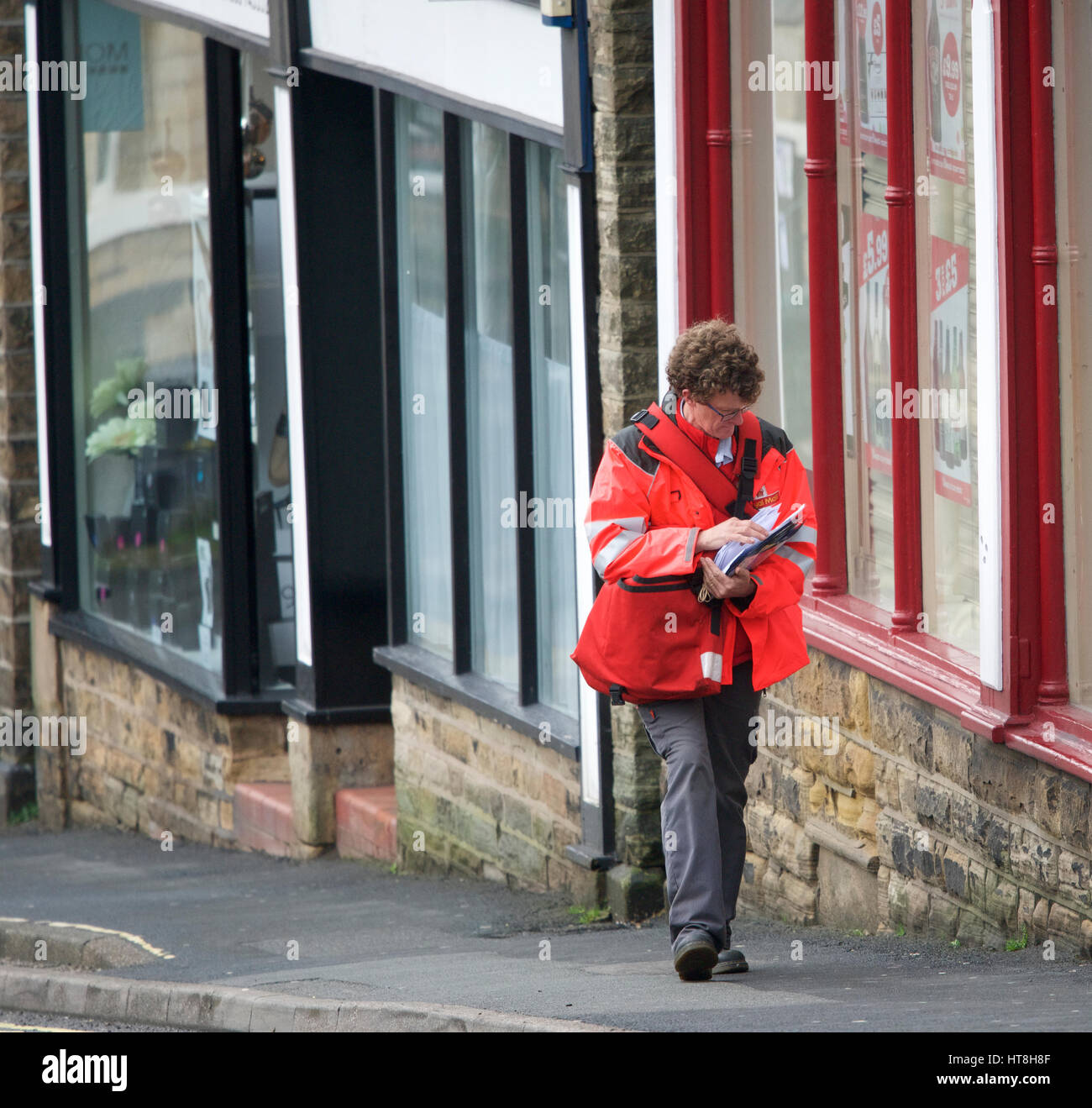 A postman on his delivery round in New Mills, Derbyshire Stock Photo ...