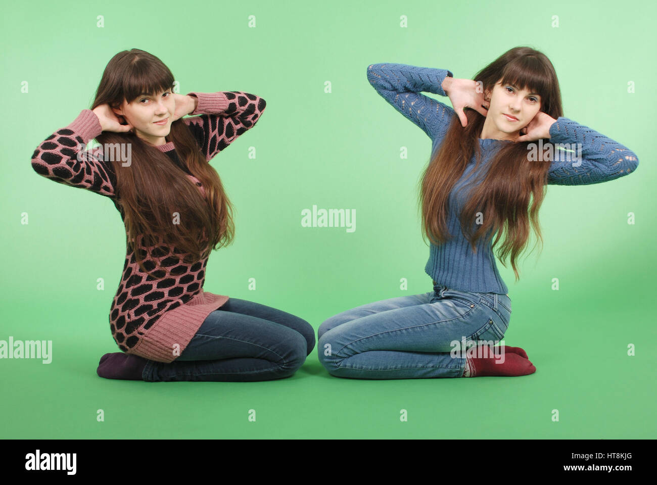 Beautiful two twins sisters on green background Stock Photo - Alamy
