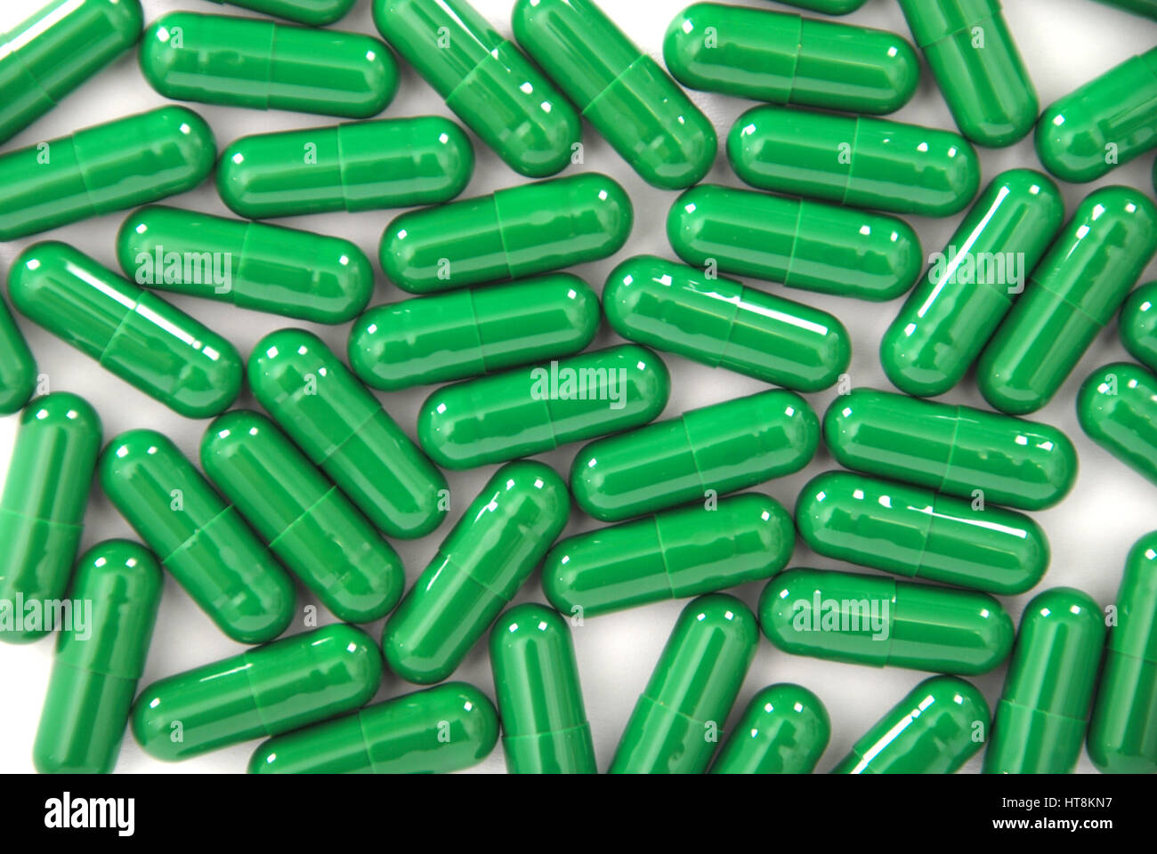 Group green capsules isolated on white background Stock Photo - Alamy