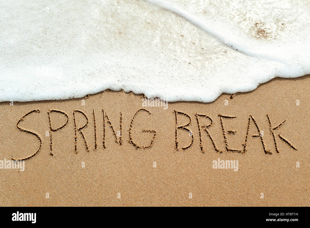 closeup of the text spring break written in the wet sand of the ...