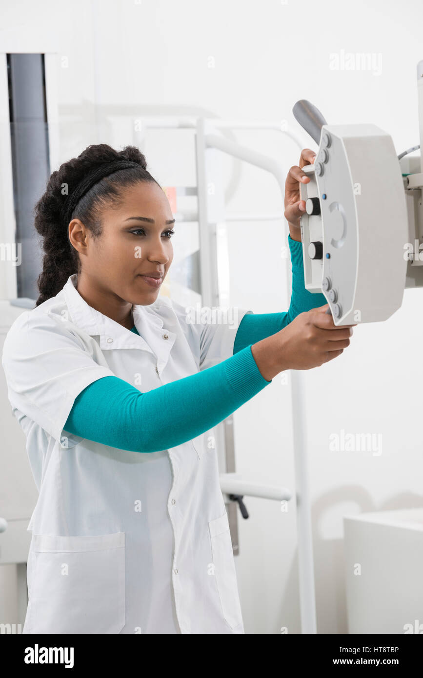 Young female doctor operating X-ray machine in examination room Stock ...