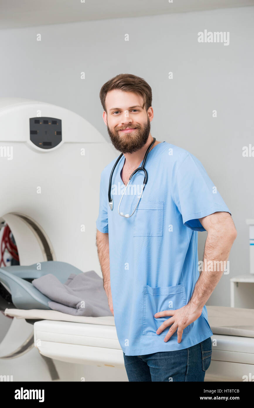 Portrait of confident male radiologist with hands on hips standing by ...