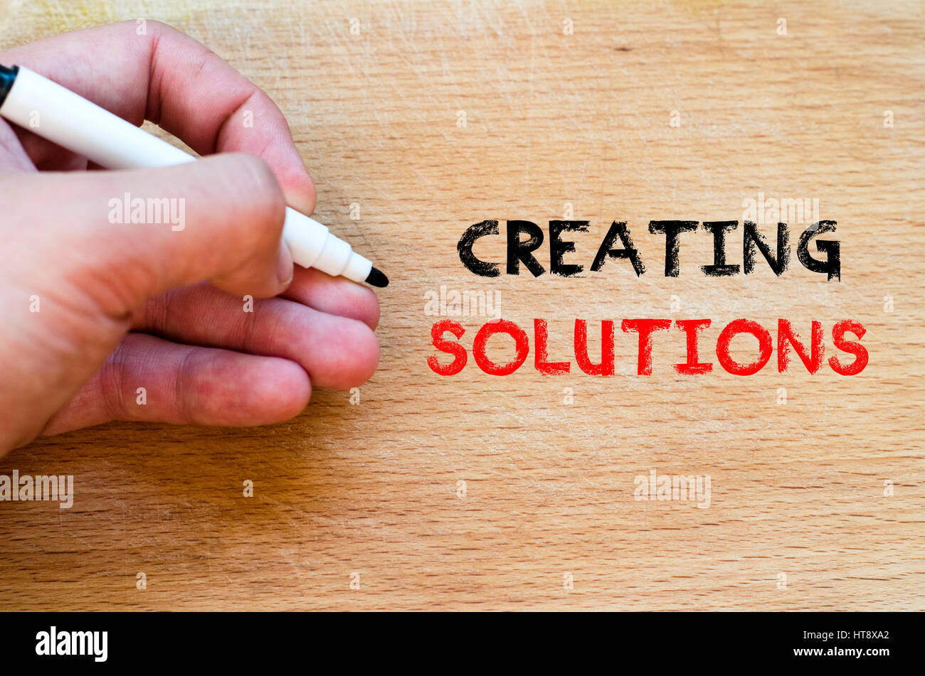 Human hand over wooden background and creating solutions text concept ...