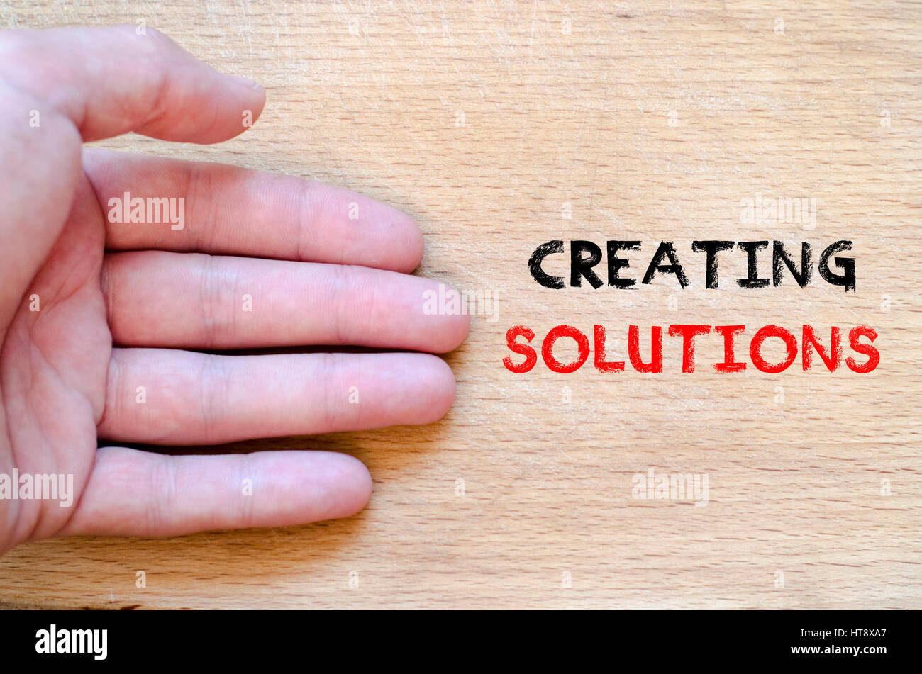 Human hand over wooden background and creating solutions text concept ...