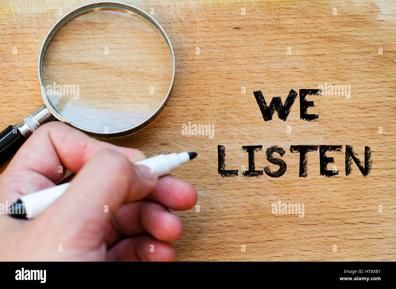 Human hand over wooden background and we listen text concept Stock ...