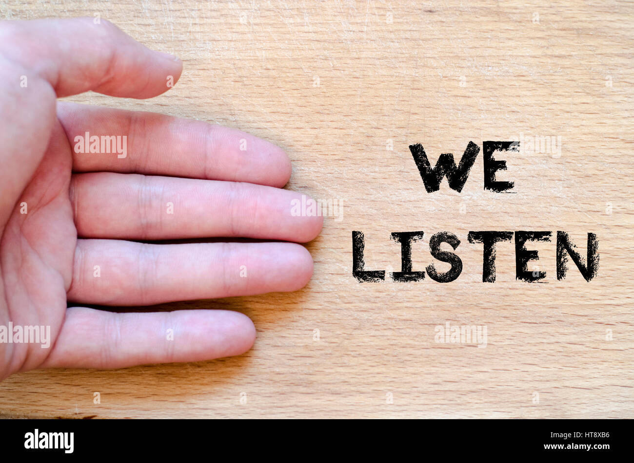 Human hand over wooden background and we listen text concept Stock ...