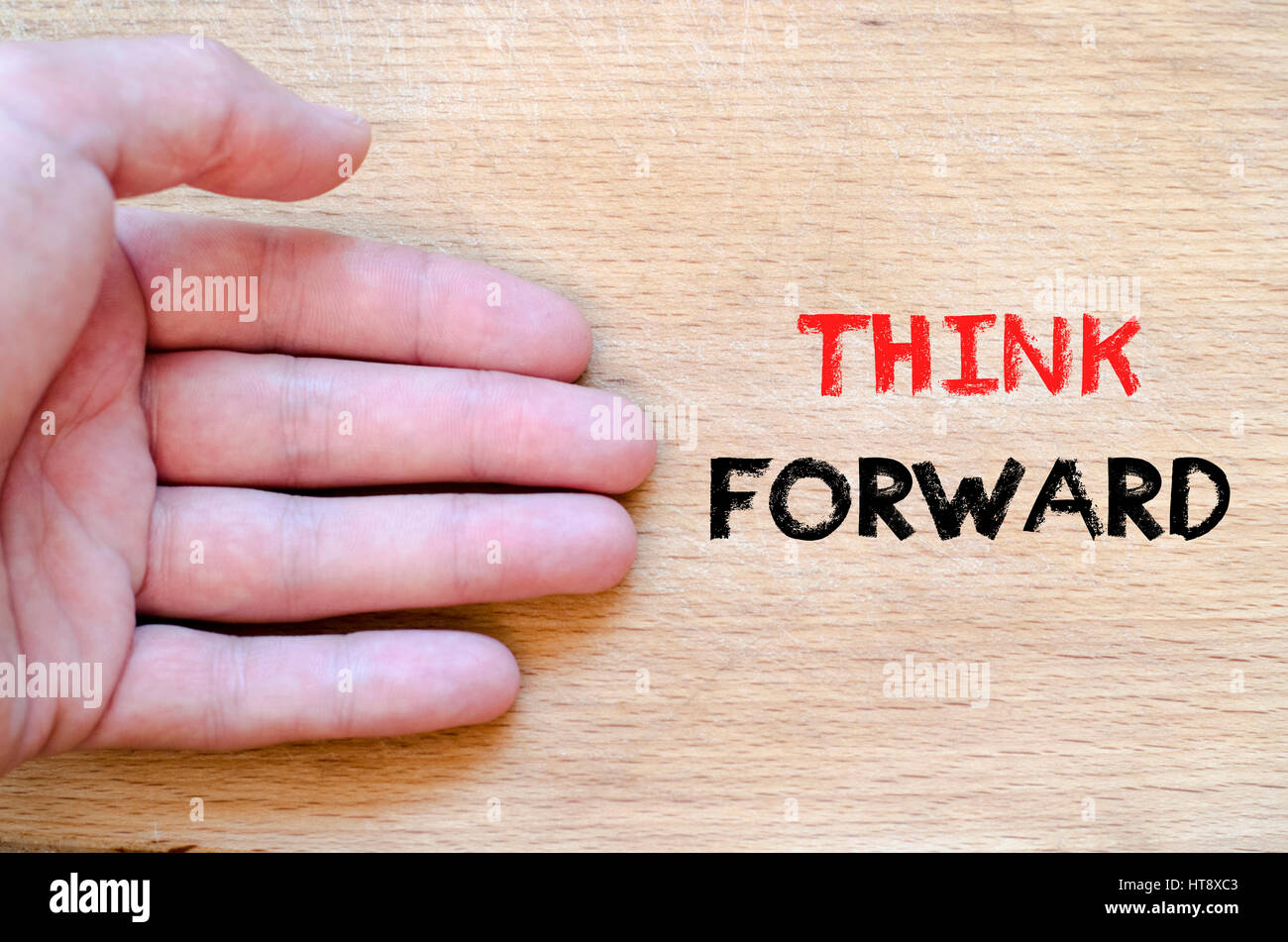 Human hand over wooden background and think forward text concept Stock ...