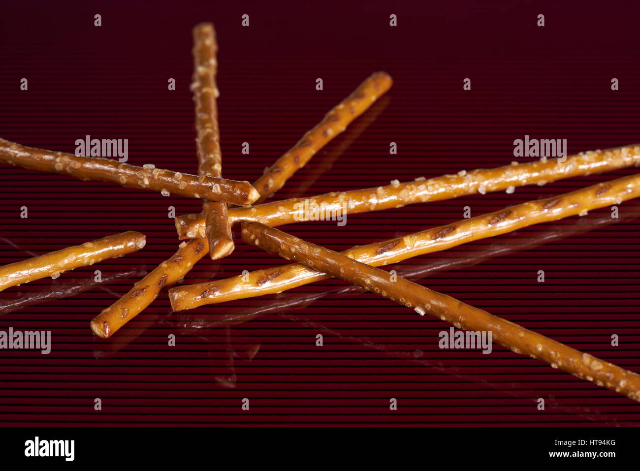 closeup of some salt sticks on dark red striped glossy ground Stock ...