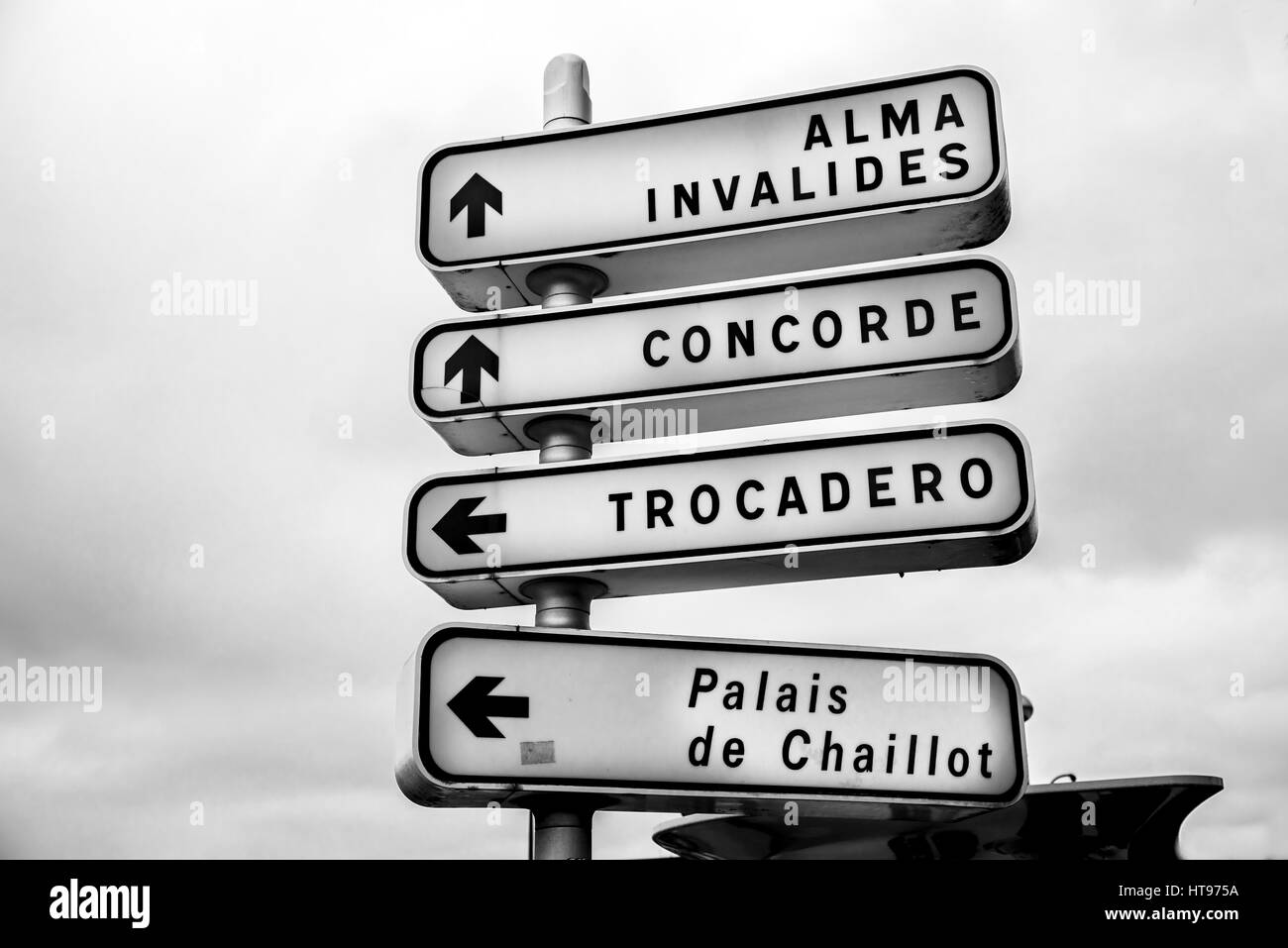 White signs with names and arrows pointing to Paris sites and landmarks ...