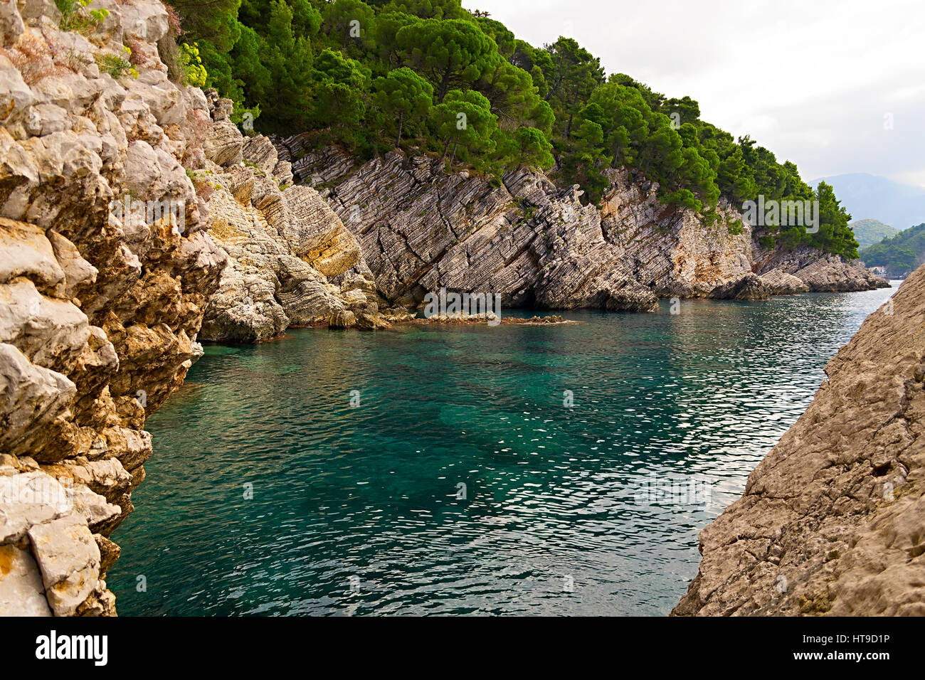 The rock is surrounded by water and sea waves beating against the rock ...