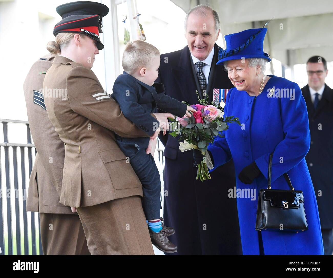 Alfie Lun, 2, is held up by his mother Michelle as he hands a bouquet ...