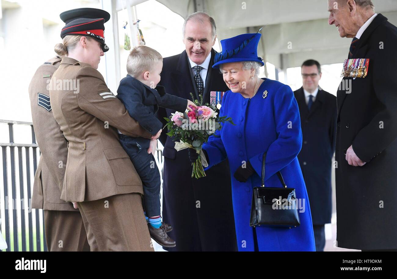 Alfie Lun, 2, is held up by his mother Michelle as he hands a bouquet ...