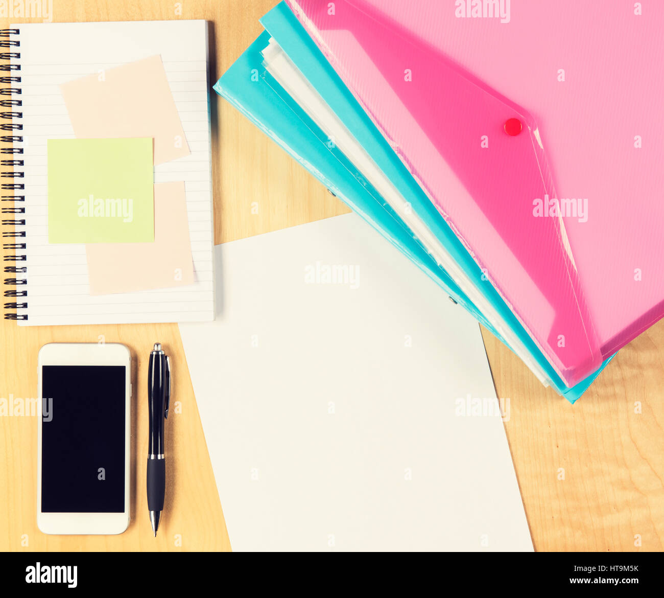 Messy office table with smartphone, notepad and filling folders. View ...