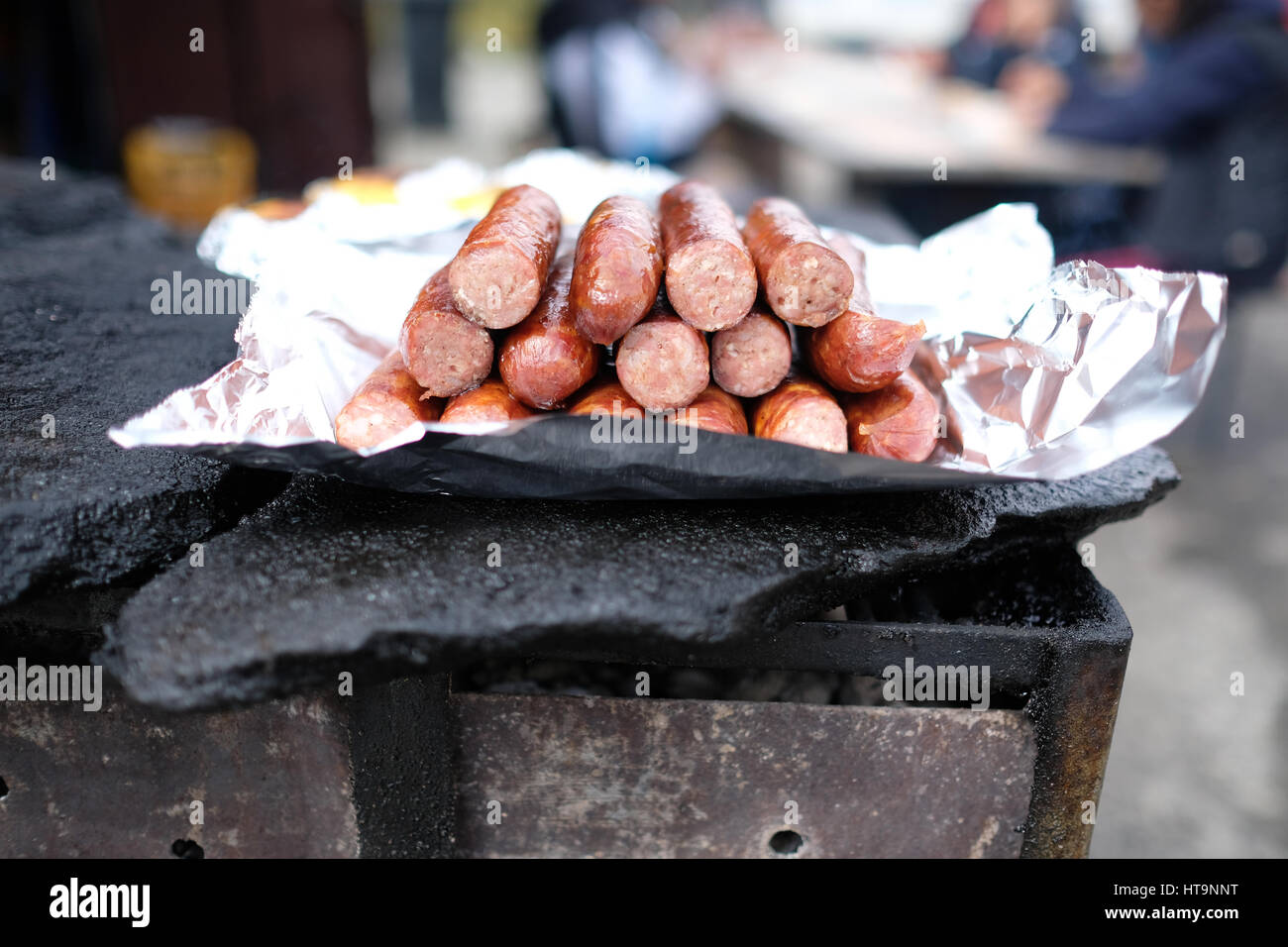 Pile of traditional Romanian grilled sausages in foil on the grill in ...