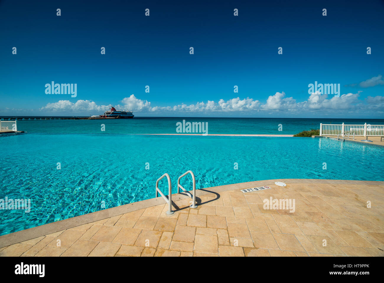 blue water swimming pool with blue ocean and a cruise ship in the ...