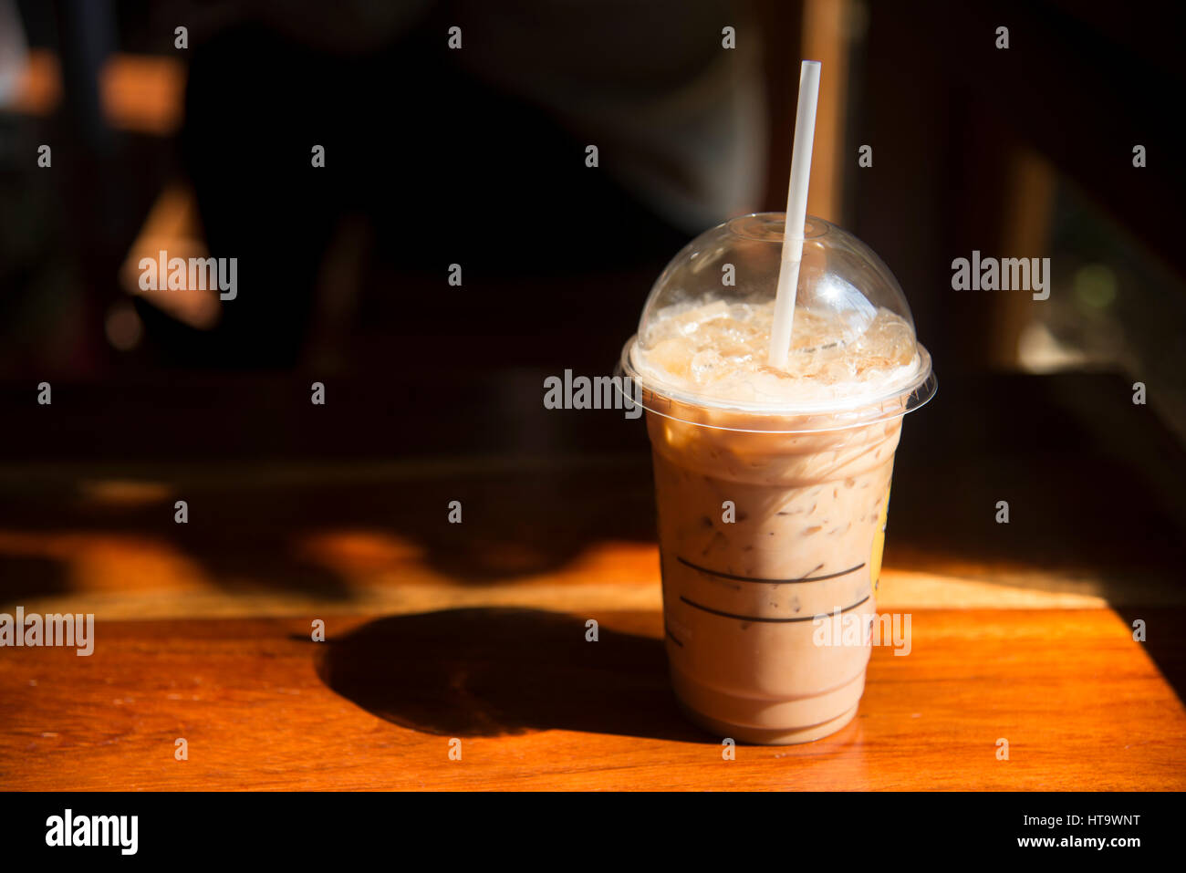 Cold coffee in plastic cup on brown wooden table at cafe Stock Photo ...