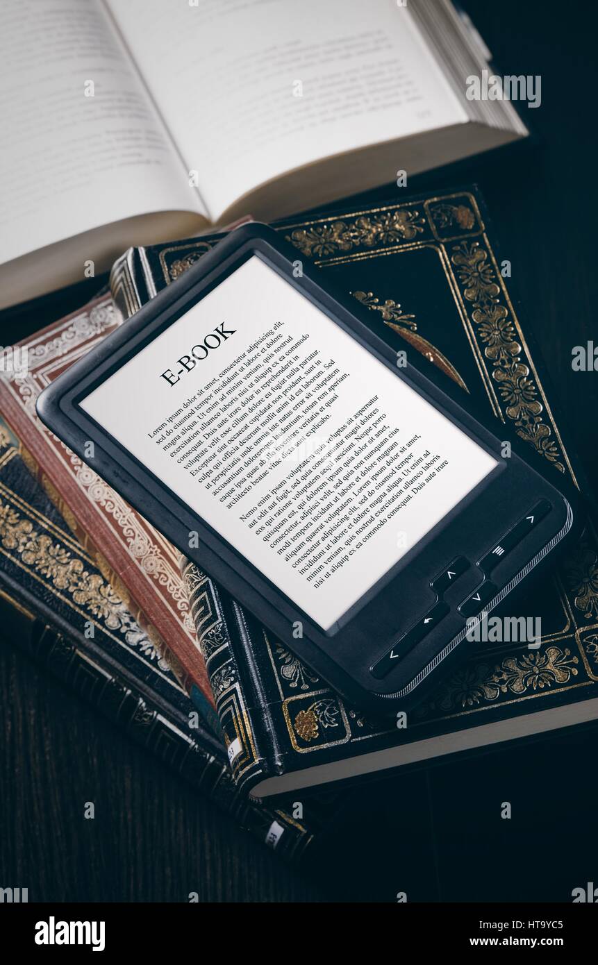 E-book reader device on desk in library. Alternative for traditional ...