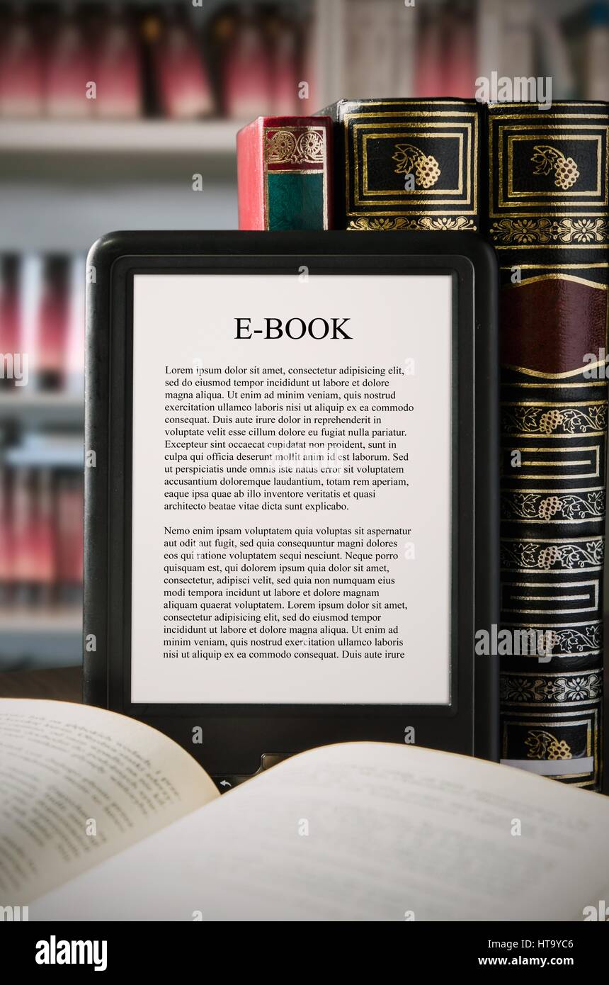 E-book reader device on desk in library. Alternative for traditional ...