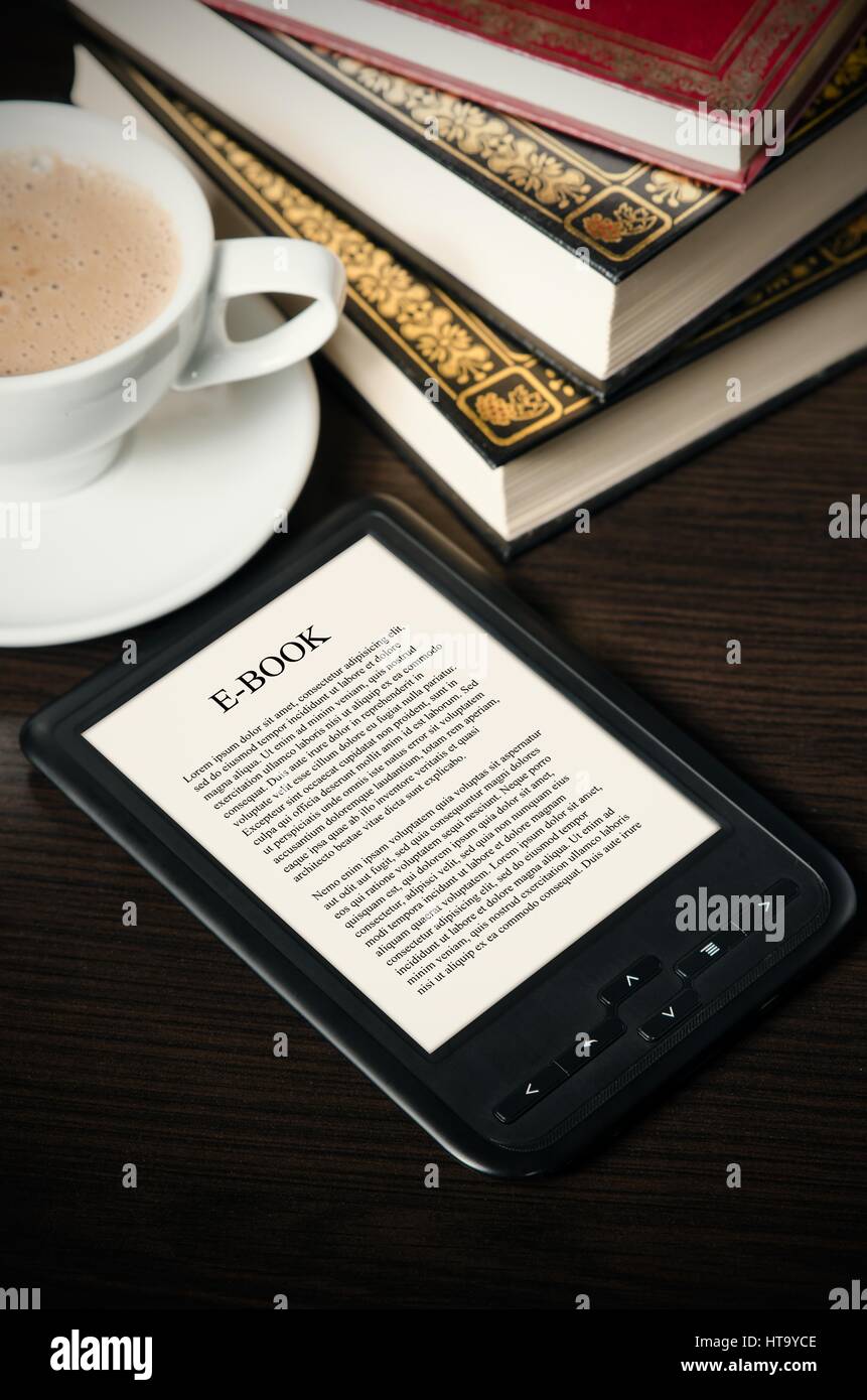 E-book reader device on desk in library. Alternative for traditional ...