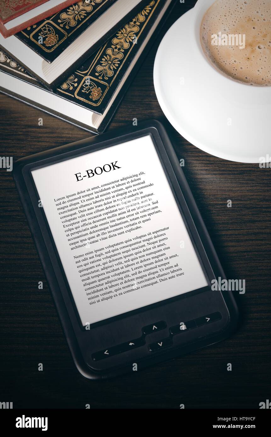 E-book reader device on desk in library. Alternative for traditional ...