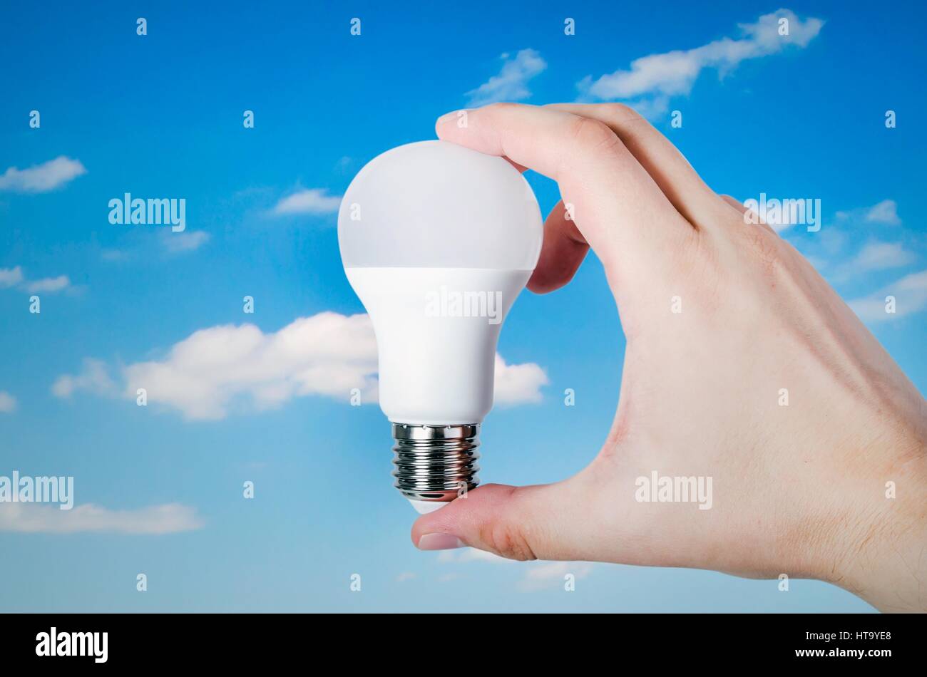 Hand holding LED bulb on sky with cloud background Stock Photo - Alamy