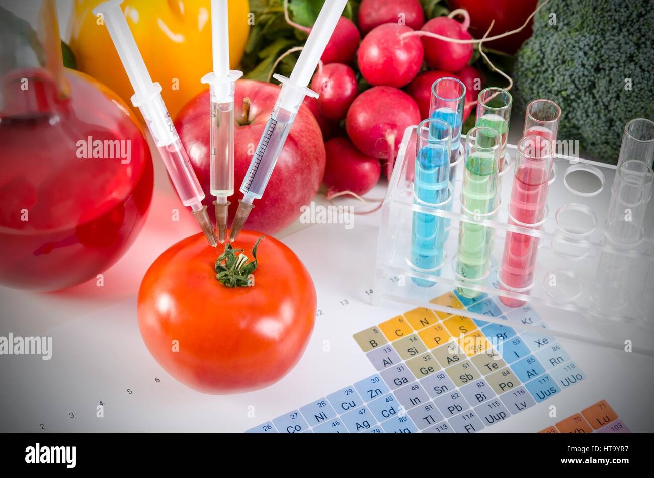 Three syringes in red tomato. Genetically modified food in lab concept ...