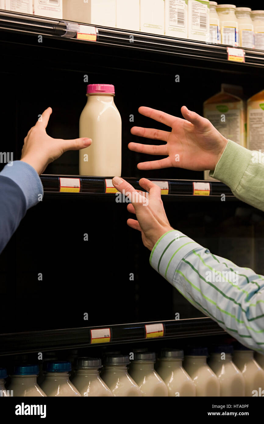 People reaching for milk Stock Photo - Alamy