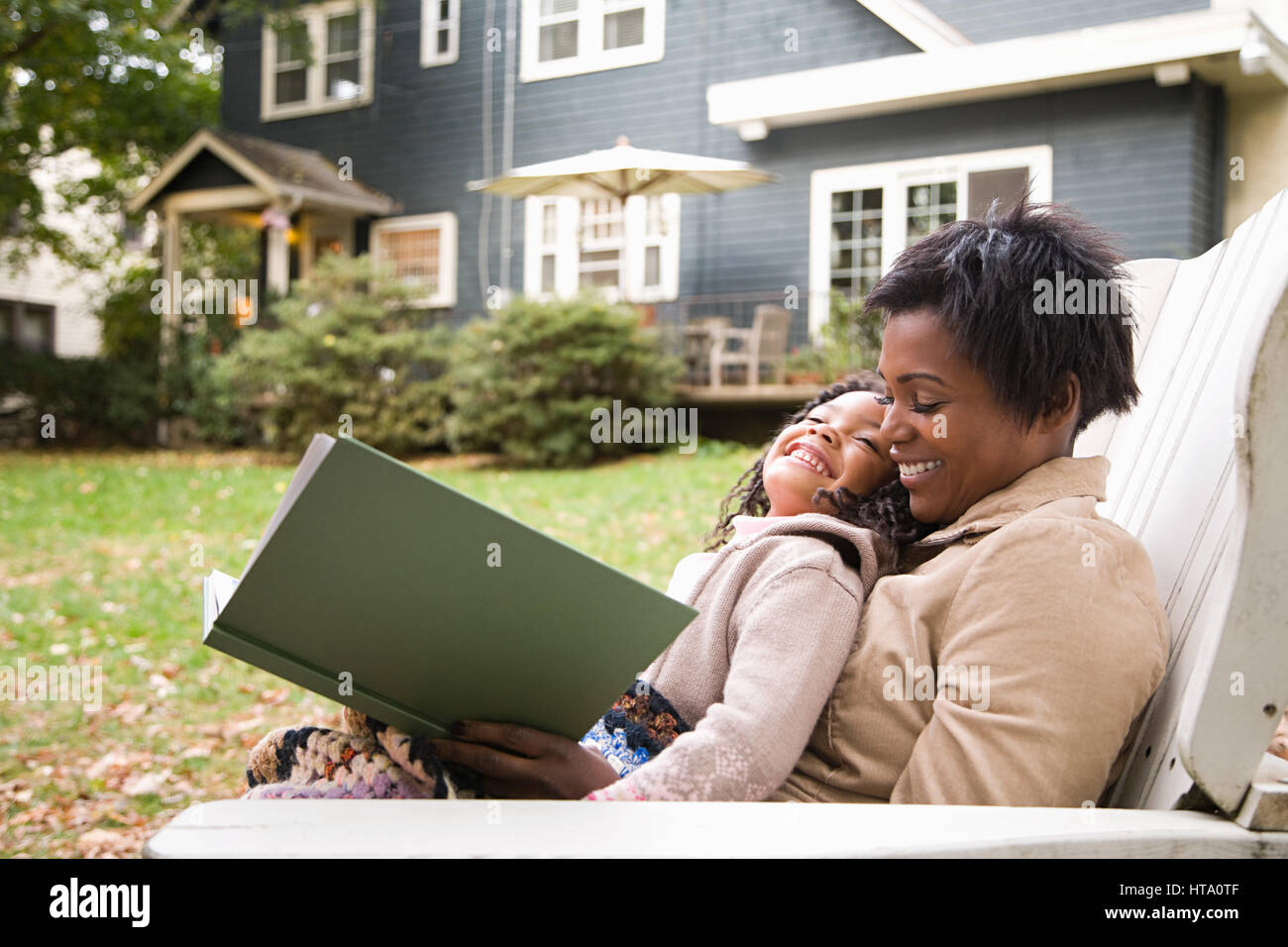 Mother and daughter with book Stock Photo - Alamy
