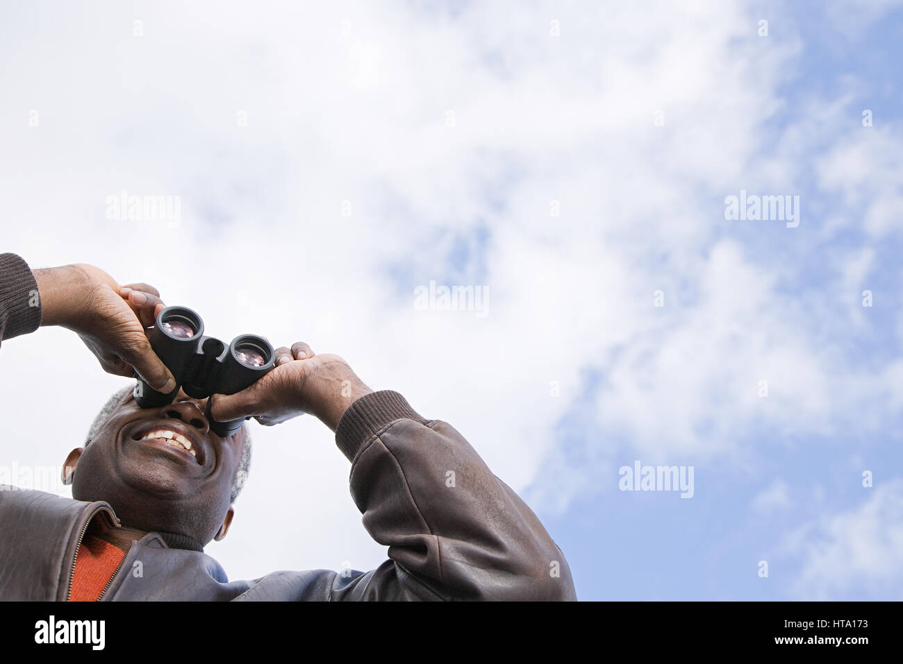One man looking through binoculars Stock Photo - Alamy