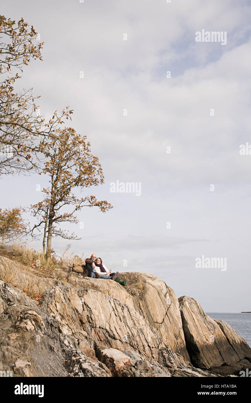 Mature couple resting on rocks Stock Photo - Alamy
