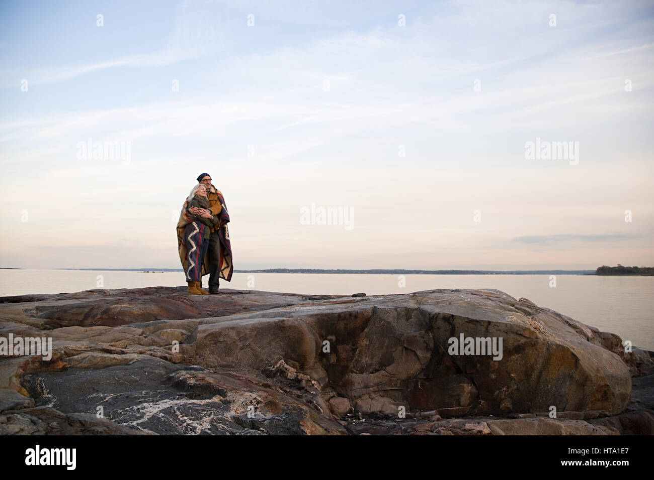 Mature couple hugging on rocks Stock Photo - Alamy