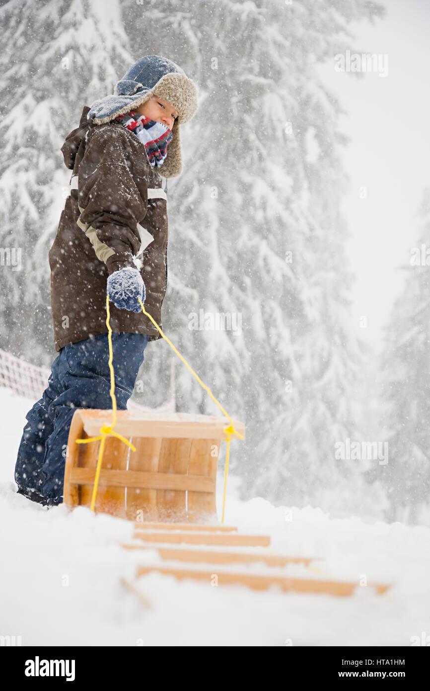 Boy with toboggan Stock Photo - Alamy