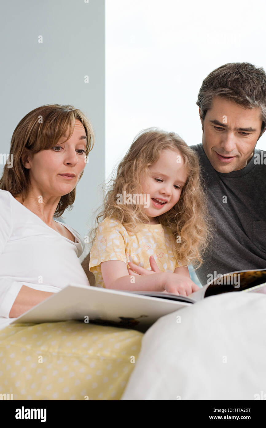 family reading a book Stock Photo - Alamy