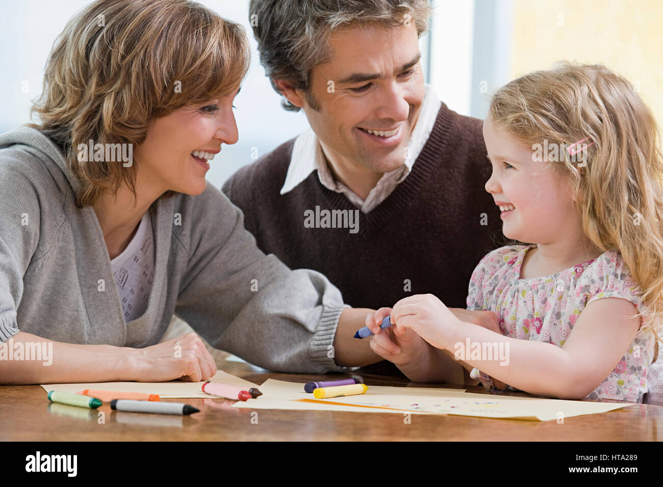 Parents helping their daughter draw Stock Photo - Alamy